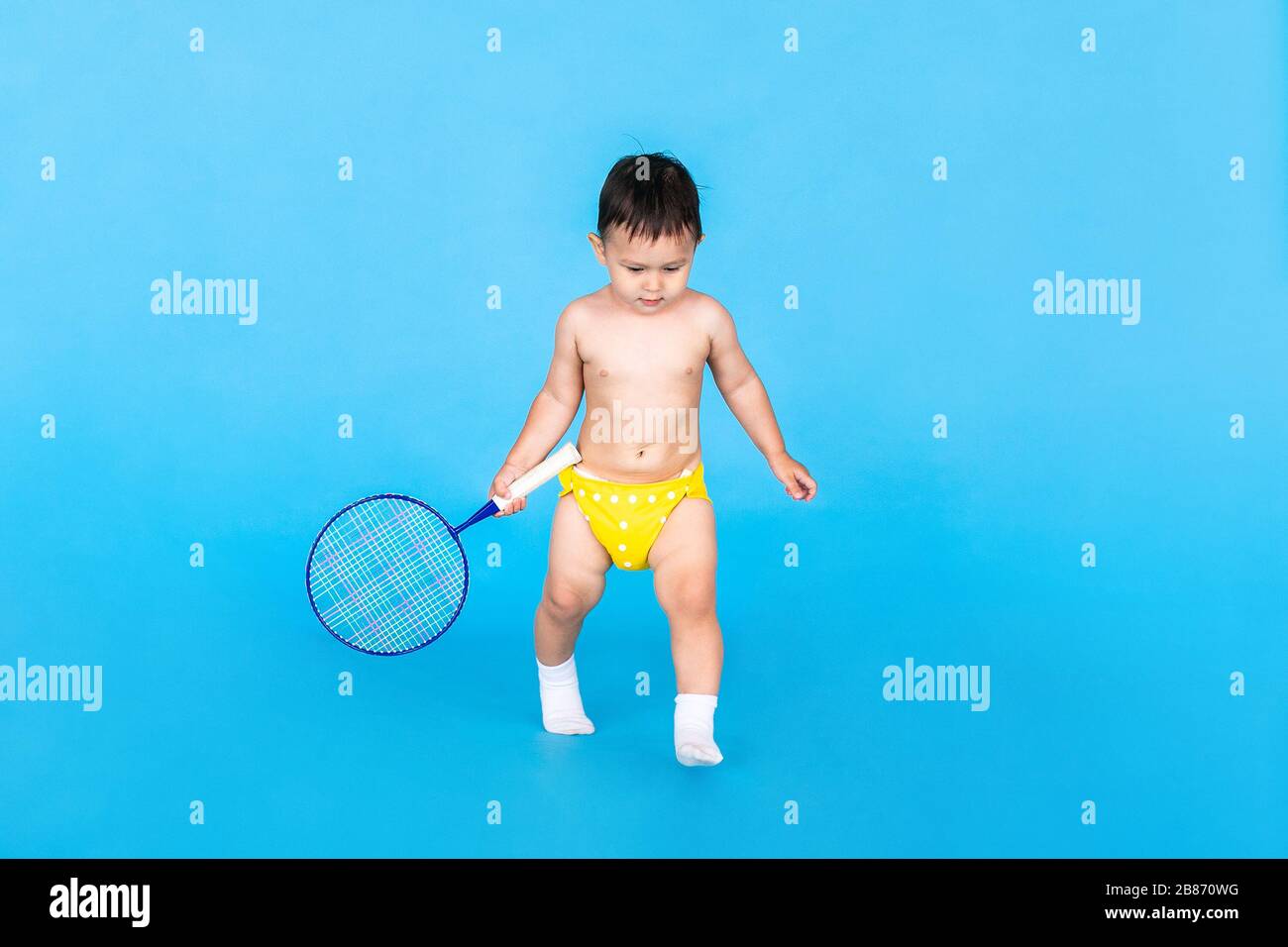 Baby boy jumping and playing badminton on blue background Stock Photo ...