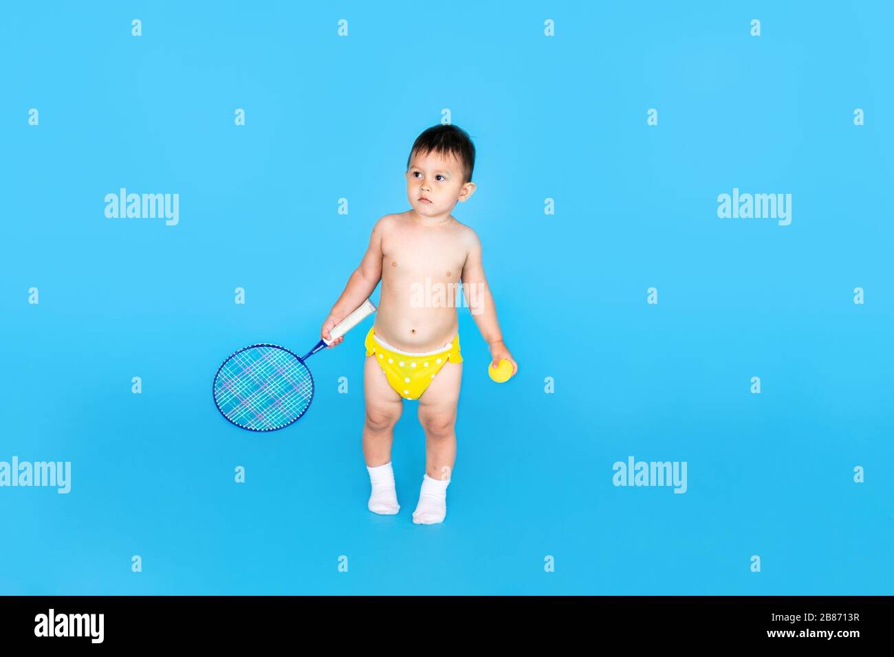 Baby boy jumping and playing badminton on blue background Stock Photo ...