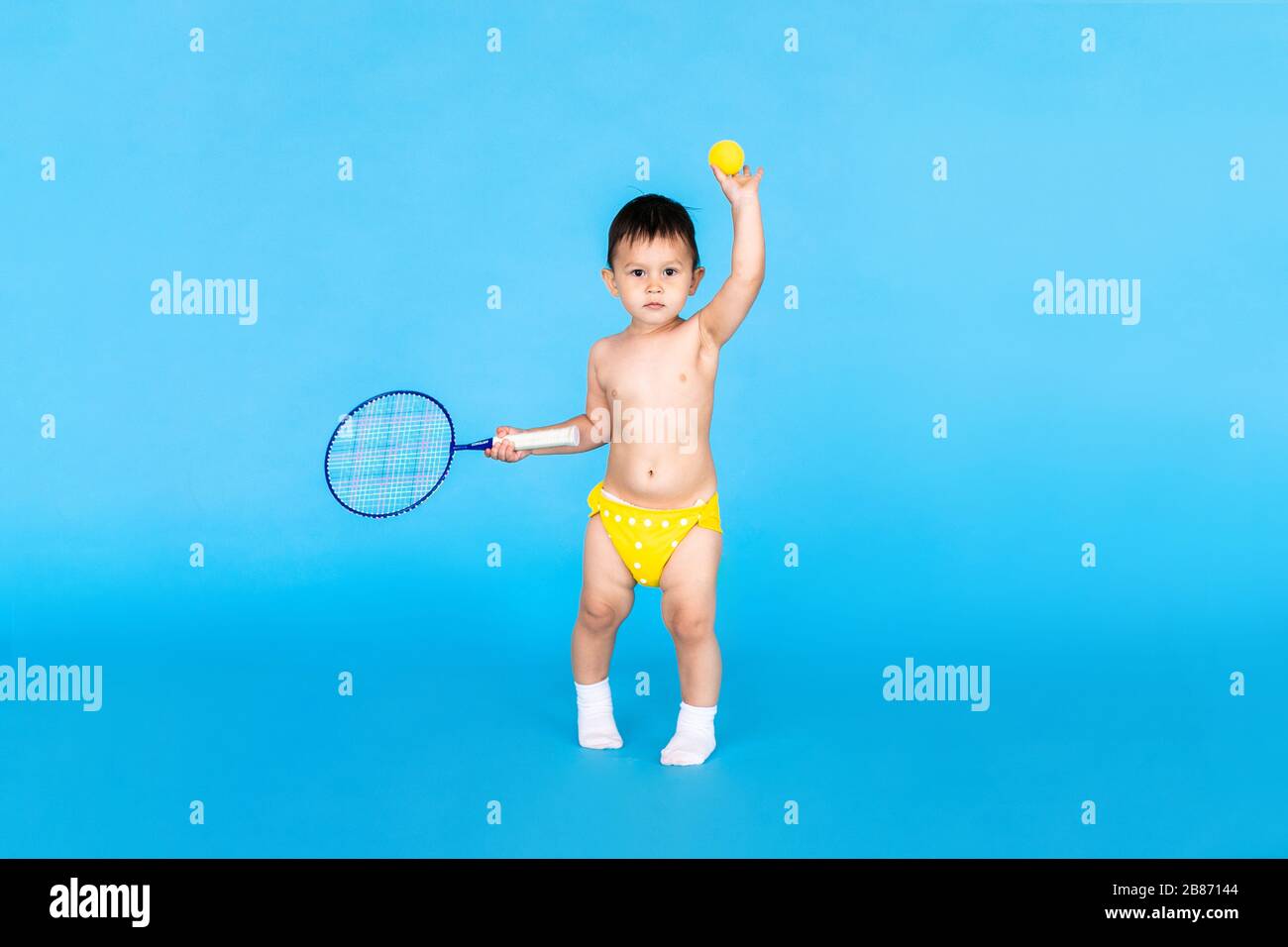 Baby boy jumping and playing badminton on blue background Stock Photo ...