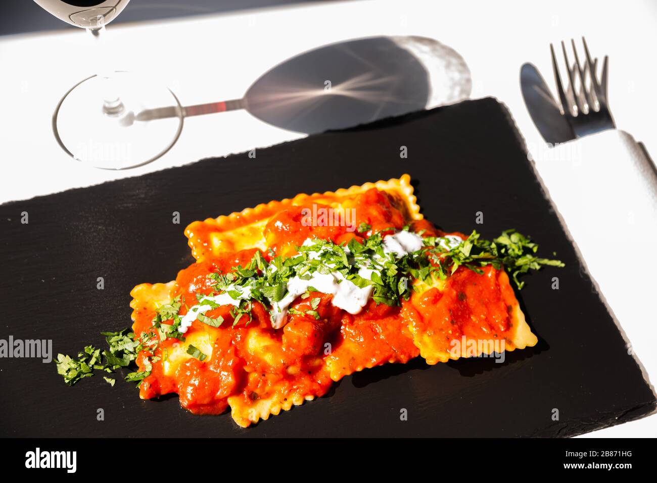 Four cheese filled ravioli in a tomato and basil sauce on the black ...