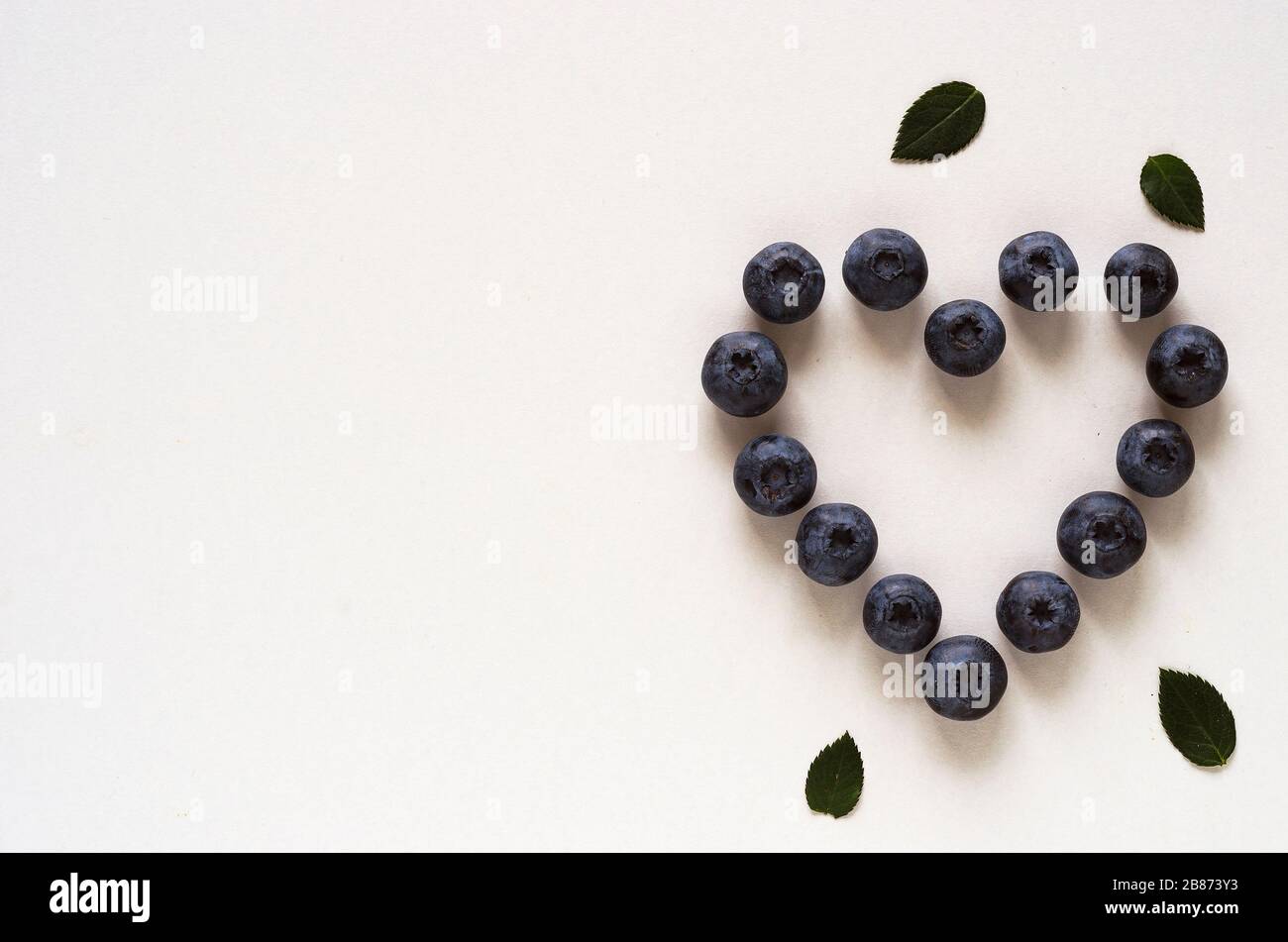 heart shaped blueberries on a white background Stock Photo - Alamy