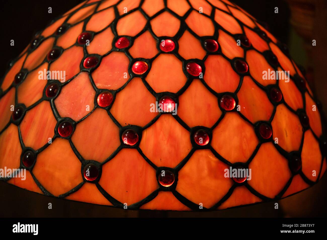 Glowing red color stained glass surface with black rhombus pattern and ...