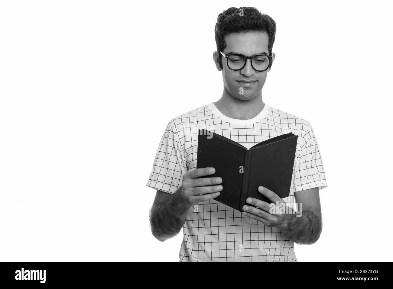 Portrait of young Persian nerd man with eyeglasses reading book Stock ...