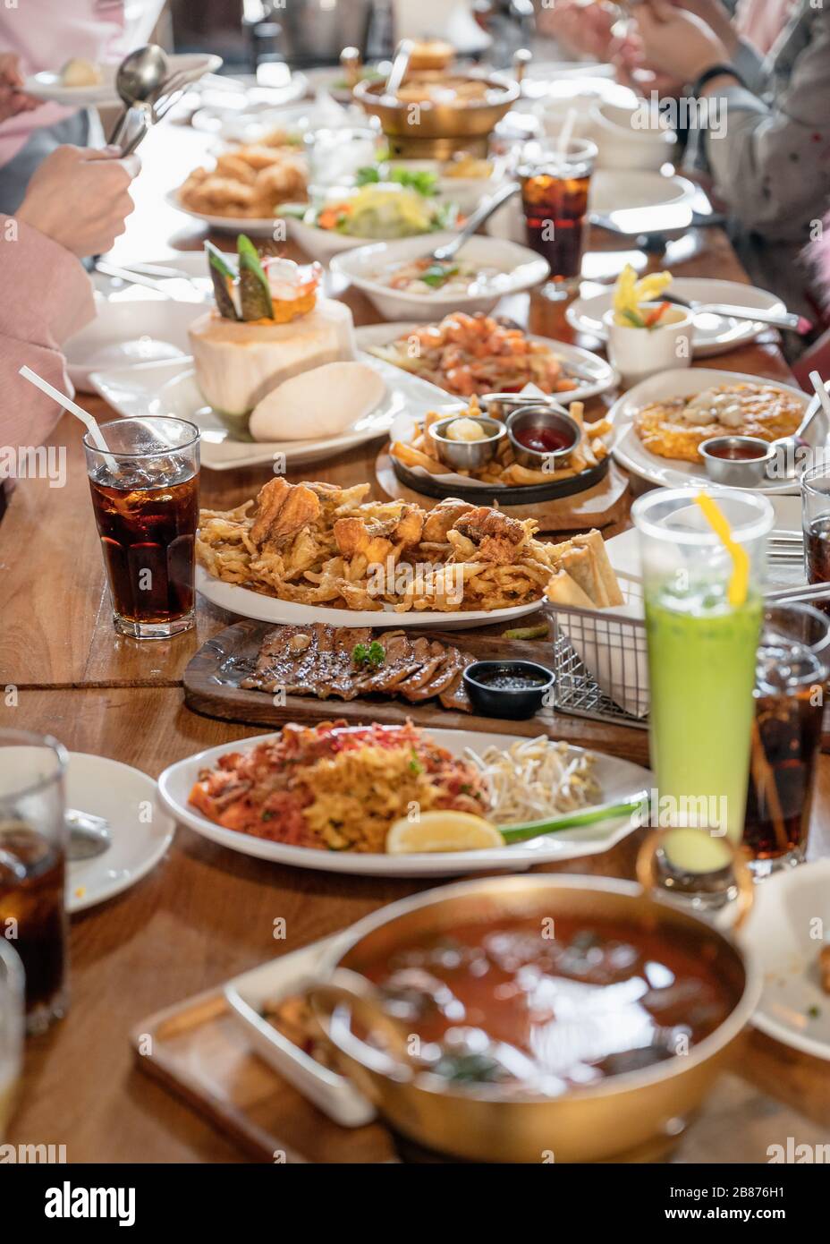 Various kind of gourmet food and drink with family eating on wooden ...