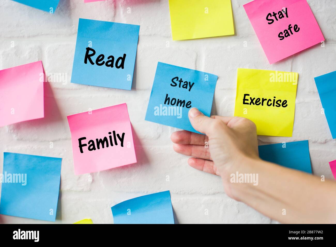 Hand Stay home words in colored notes Stock Photo - Alamy