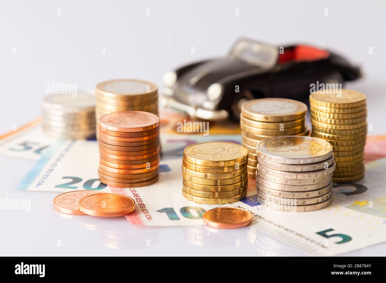 Stack of euro coins on euro banknotes and classic car for backgrounds ...