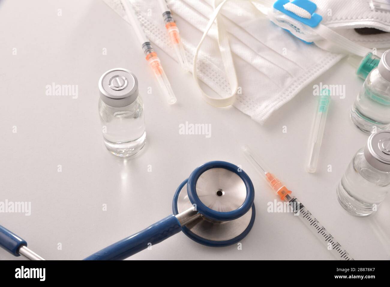 Vials and syringes on white table with medical equipmen. Top view ...