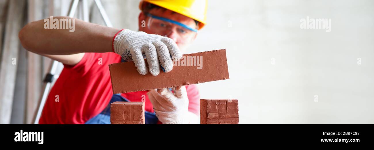 Male person constructing brickwall Stock Photo - Alamy