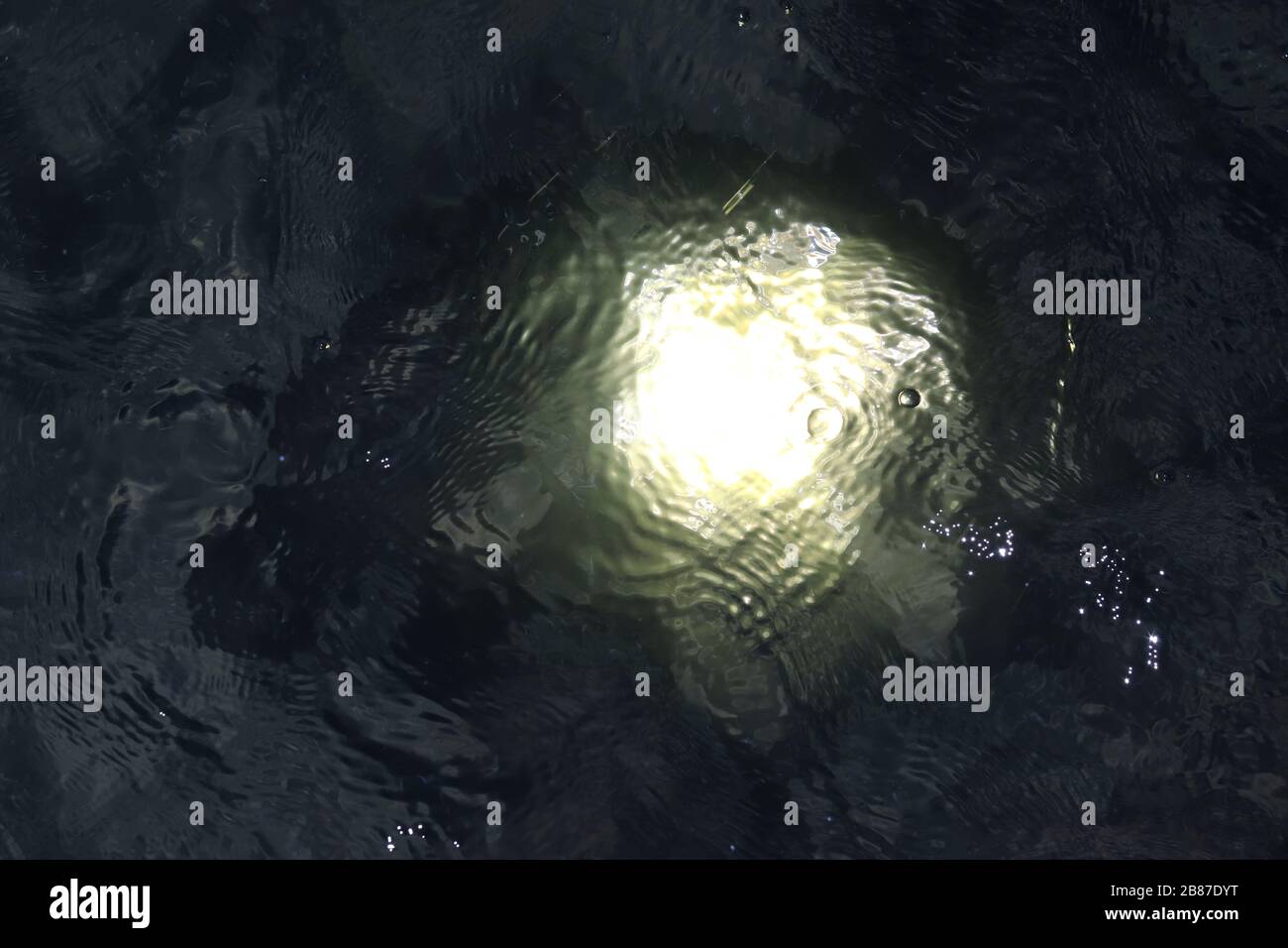 water surface with lighting lamp in swimming pool, underwater lamp ...