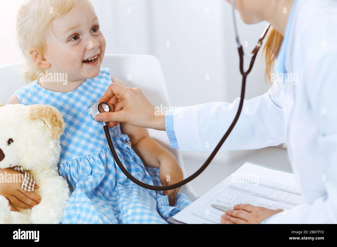 Happy smiling child patient at usual medical inspection. Doctor and ...