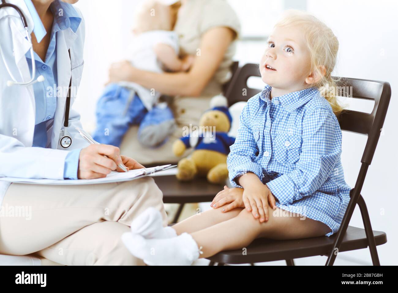 Happy smiling child patient at usual medical inspection. Doctor and ...