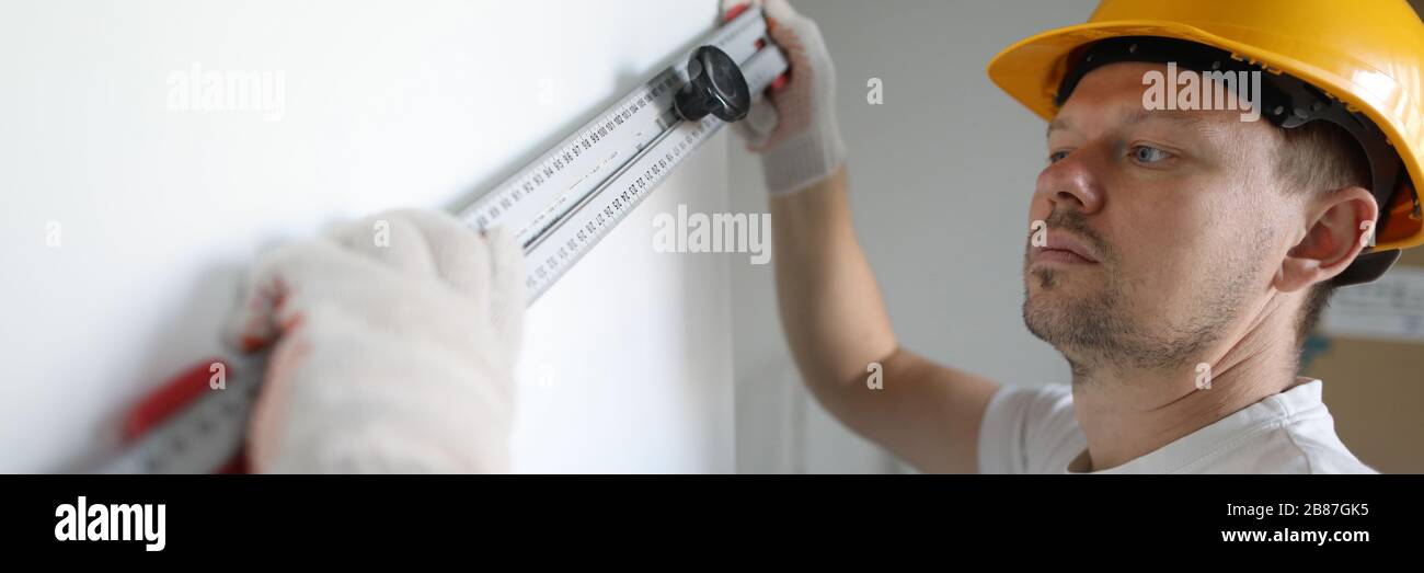 Worker making wall straight Stock Photo - Alamy