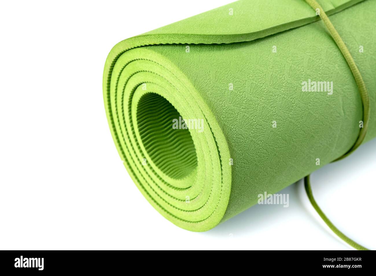 Green rolled sleeping mat isolated on white background Stock Photo - Alamy