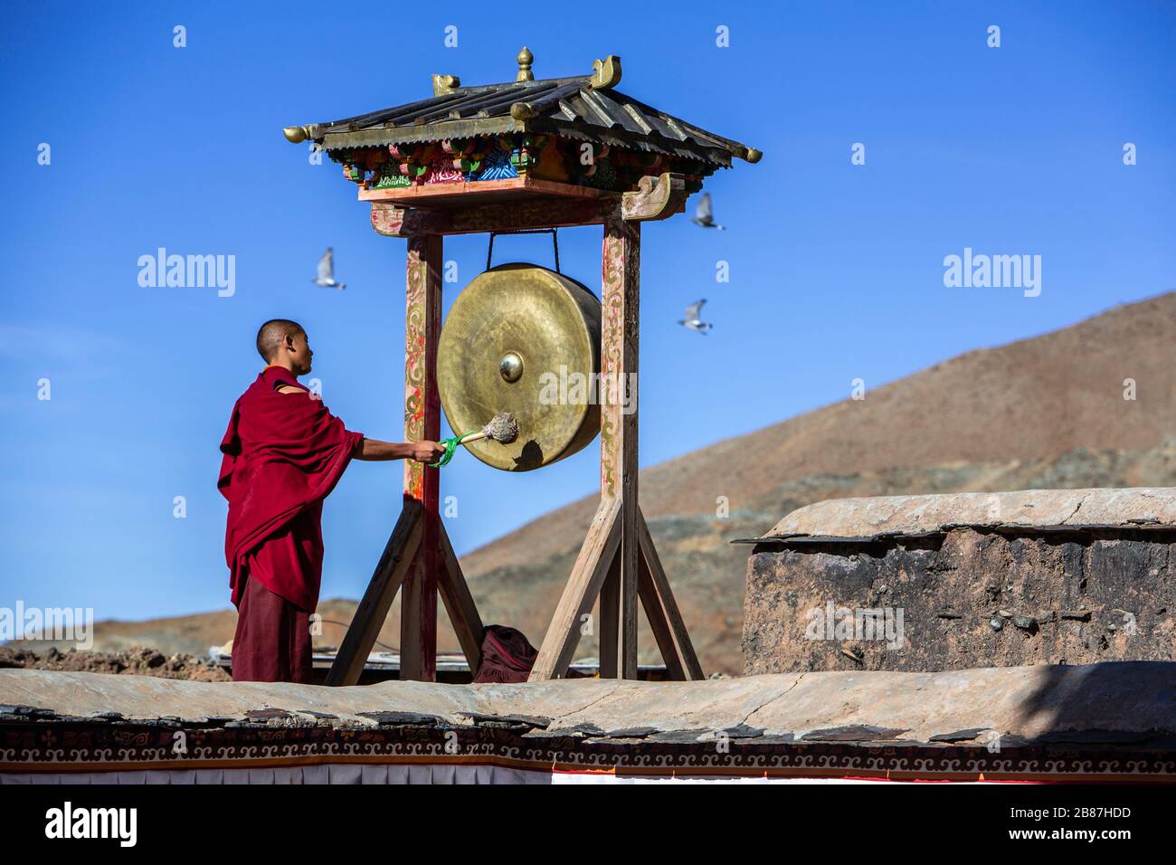 Tibetan monk hitting gong at Ngor Monastery in Shigatse, Tibet Stock ...