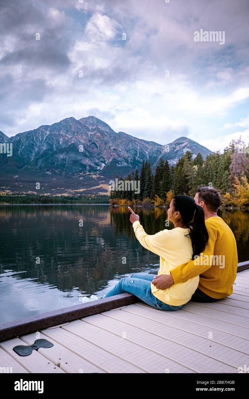 couple by the lake watching sunset, Pyramid lake Jasper during autumn ...