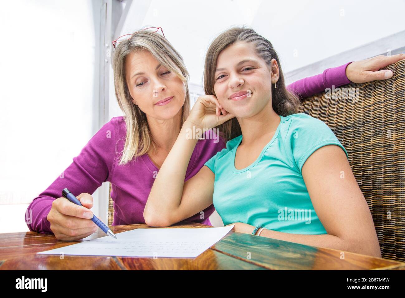 pretty teen girl doing its homework in complicity with a female teacher ...