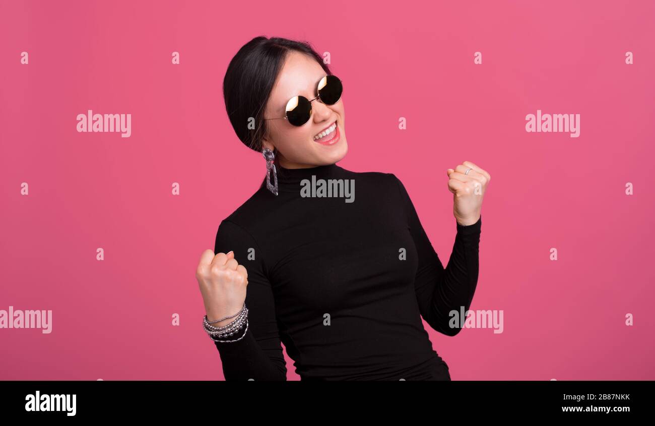 Photo of cheerful young woman celebrating victory over pink background ...