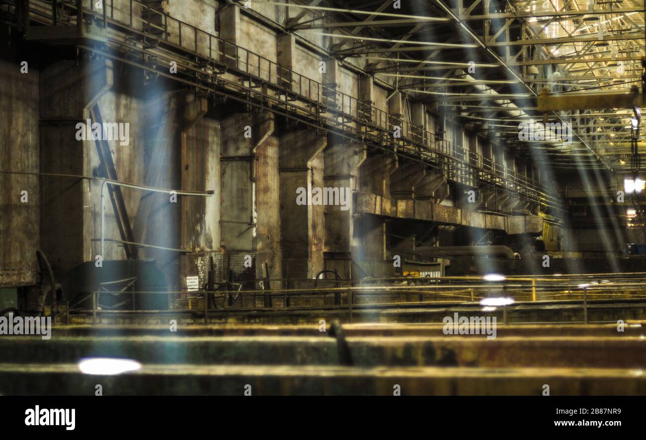 Industrial interior of old factory building, old rusty bathtub of acid ...