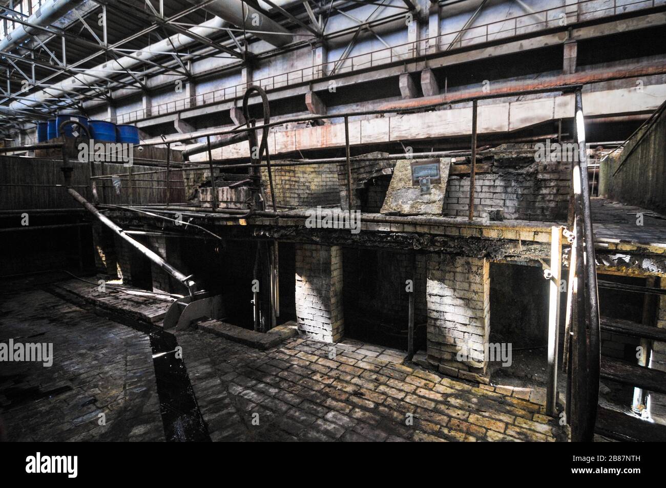 Industrial interior of old factory building, old rusty bathtub of acid ...