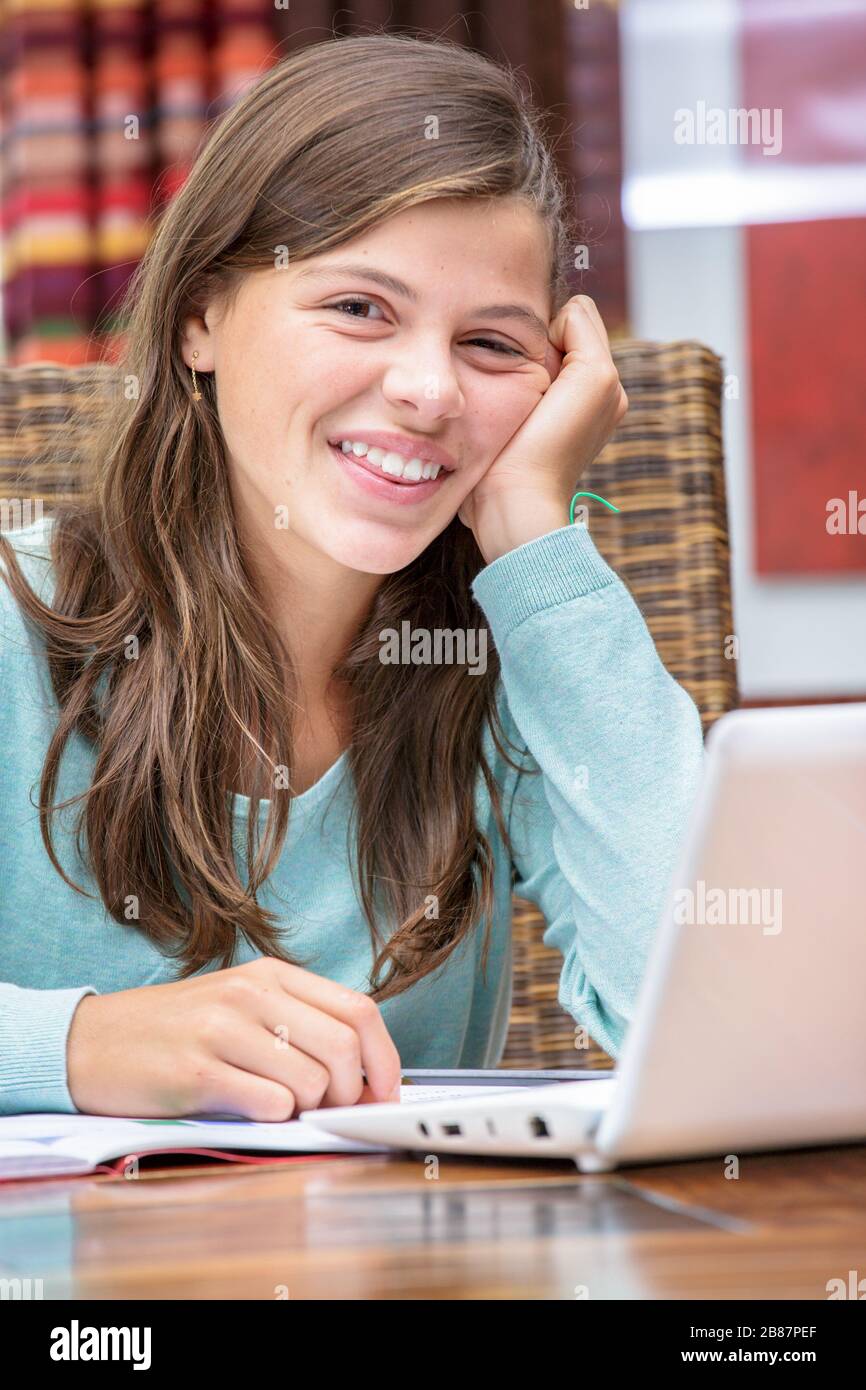 pretty student girl doing homework at home with a laptop Stock Photo ...