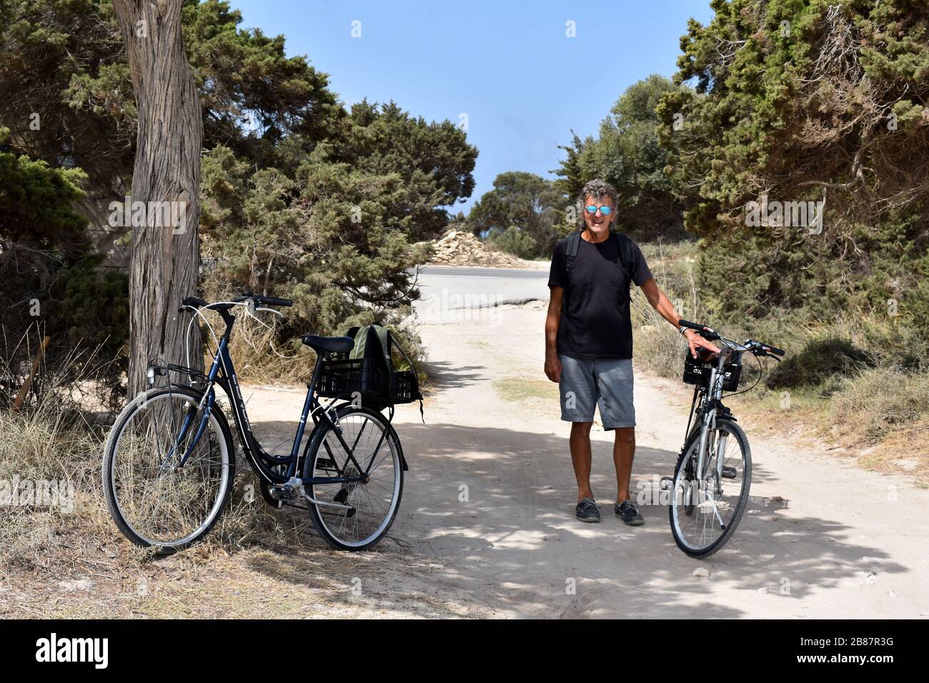 Man having a break from riding his bike while touring Formentera island ...