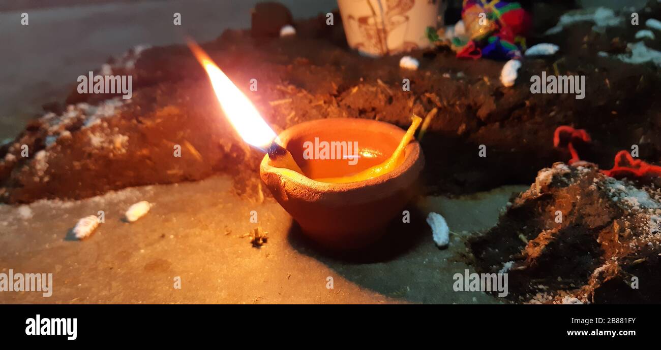 soil or clay lamp radiating light in dark. concept of removing darkness ...