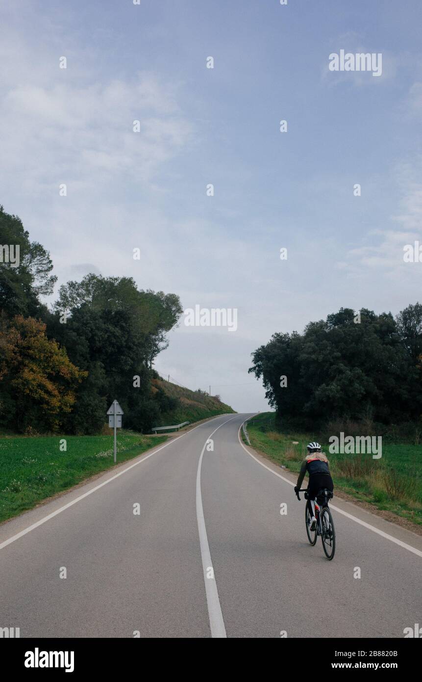 Female professional cyclist rides fast through a road in spain Stock ...