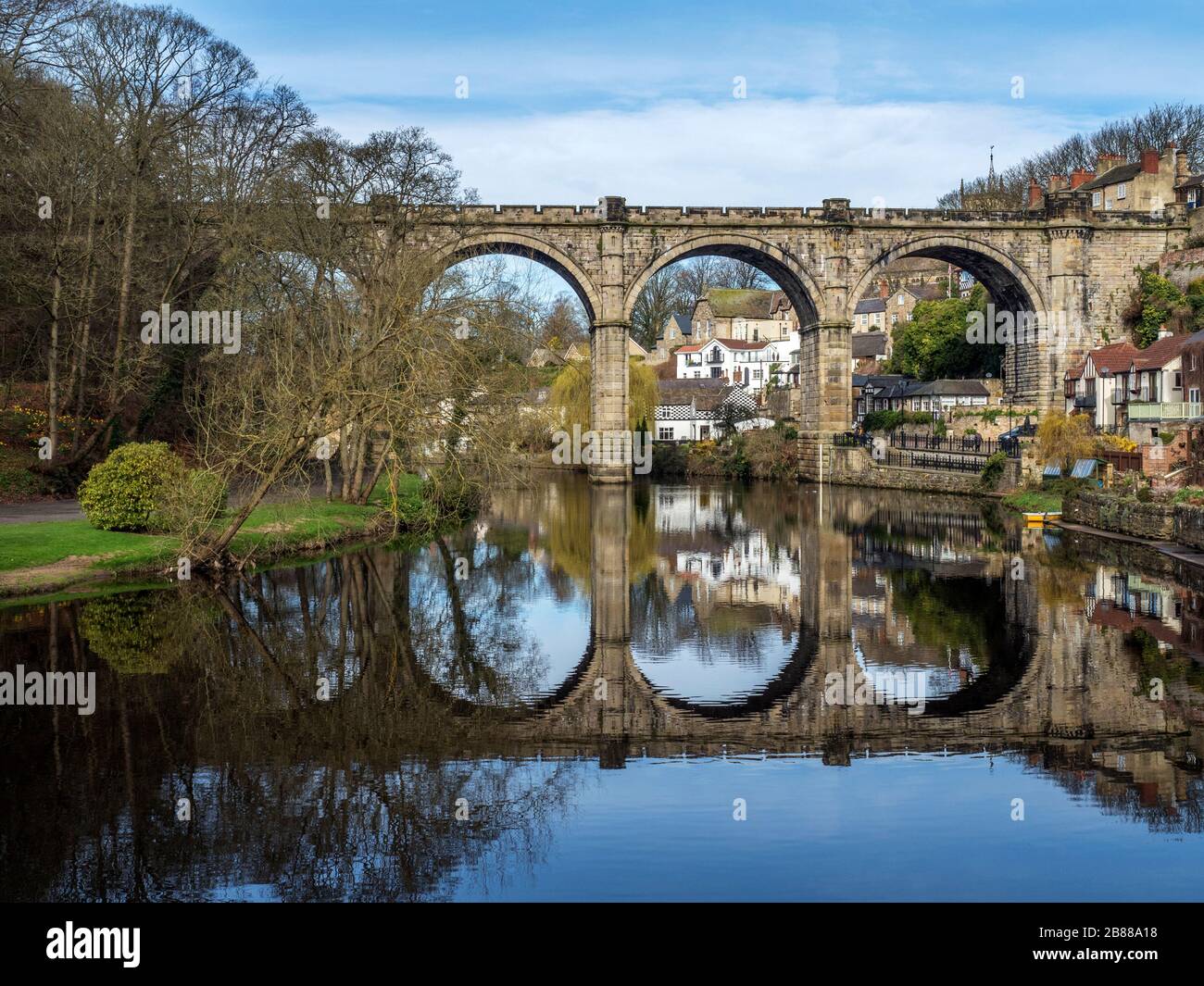 The Victorian railway viaduct reflected in the River Nidd in early ...