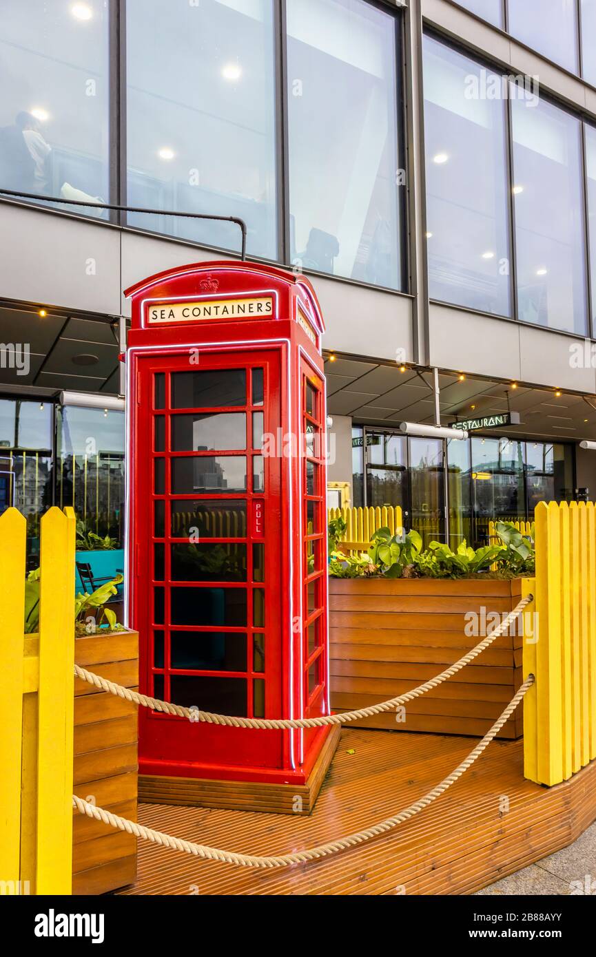 Traditional red telephone box outside Sea Containers House, a hotel and ...