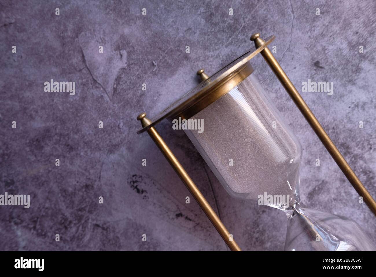 Sand running through the bulbs of an hourglass measuring the passing ...