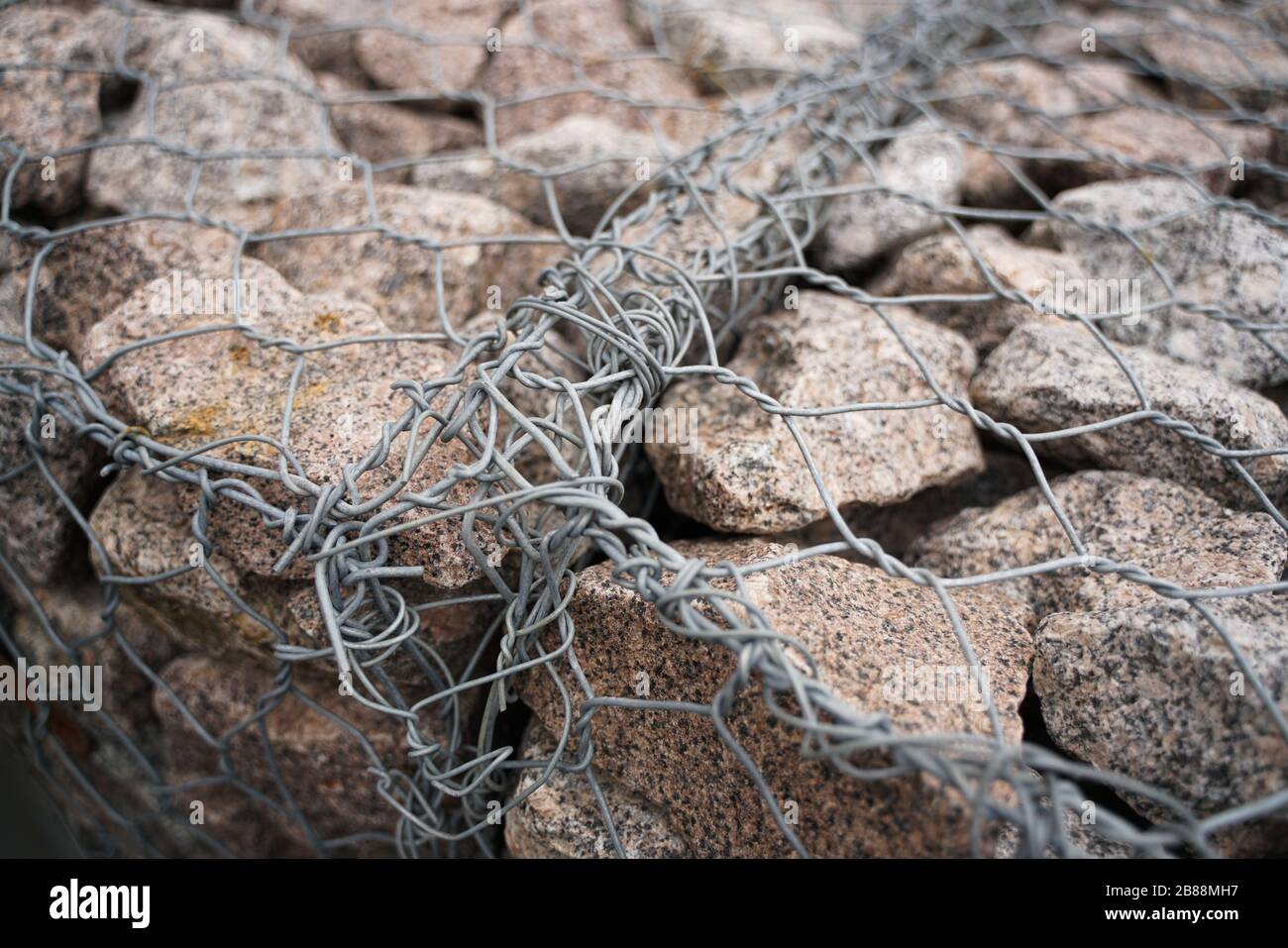 Detail shot of a stone retaining wall with stones in a steel cage ...