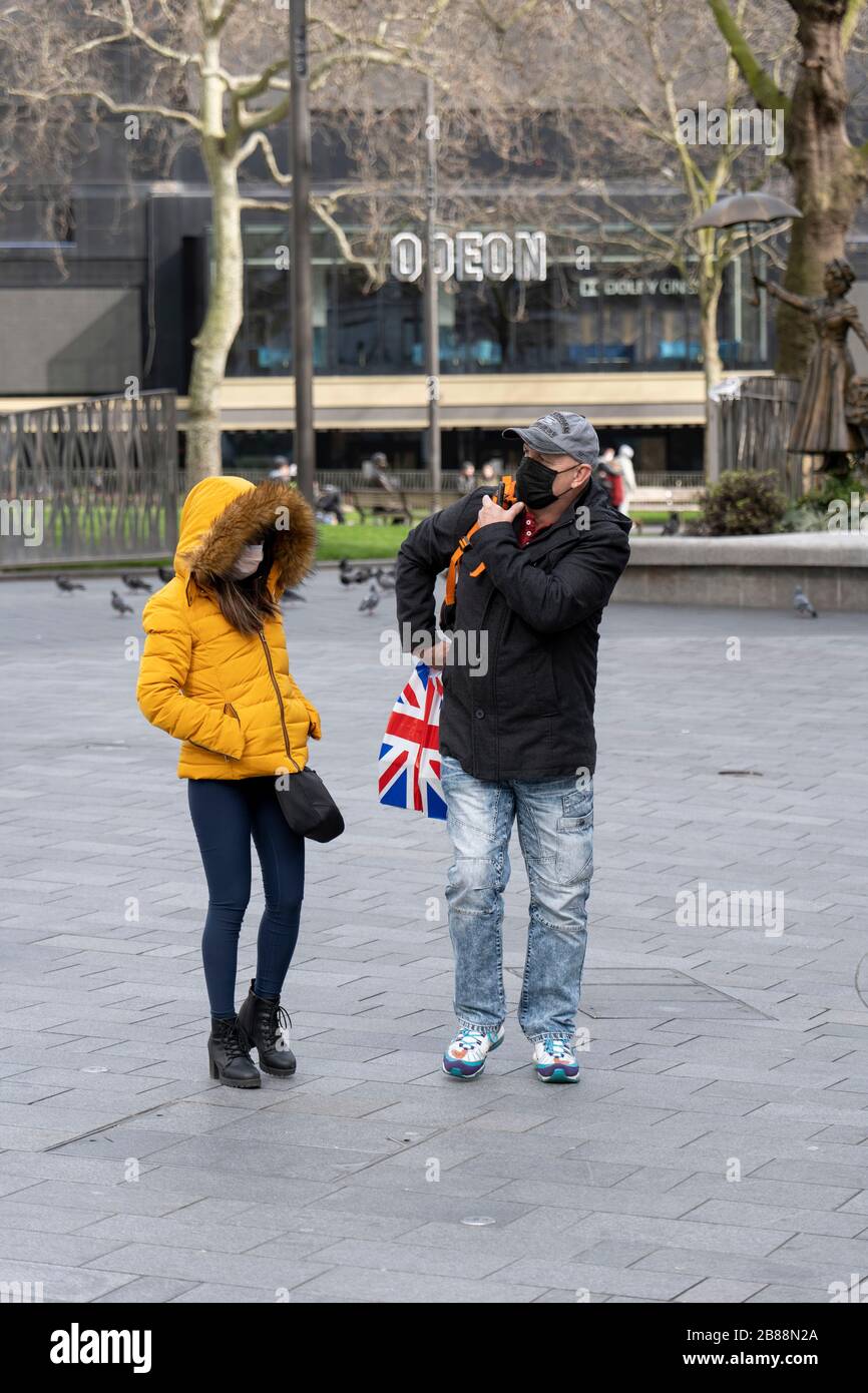 London, England, UK. 20th March 2020. A couple wear protective face ...