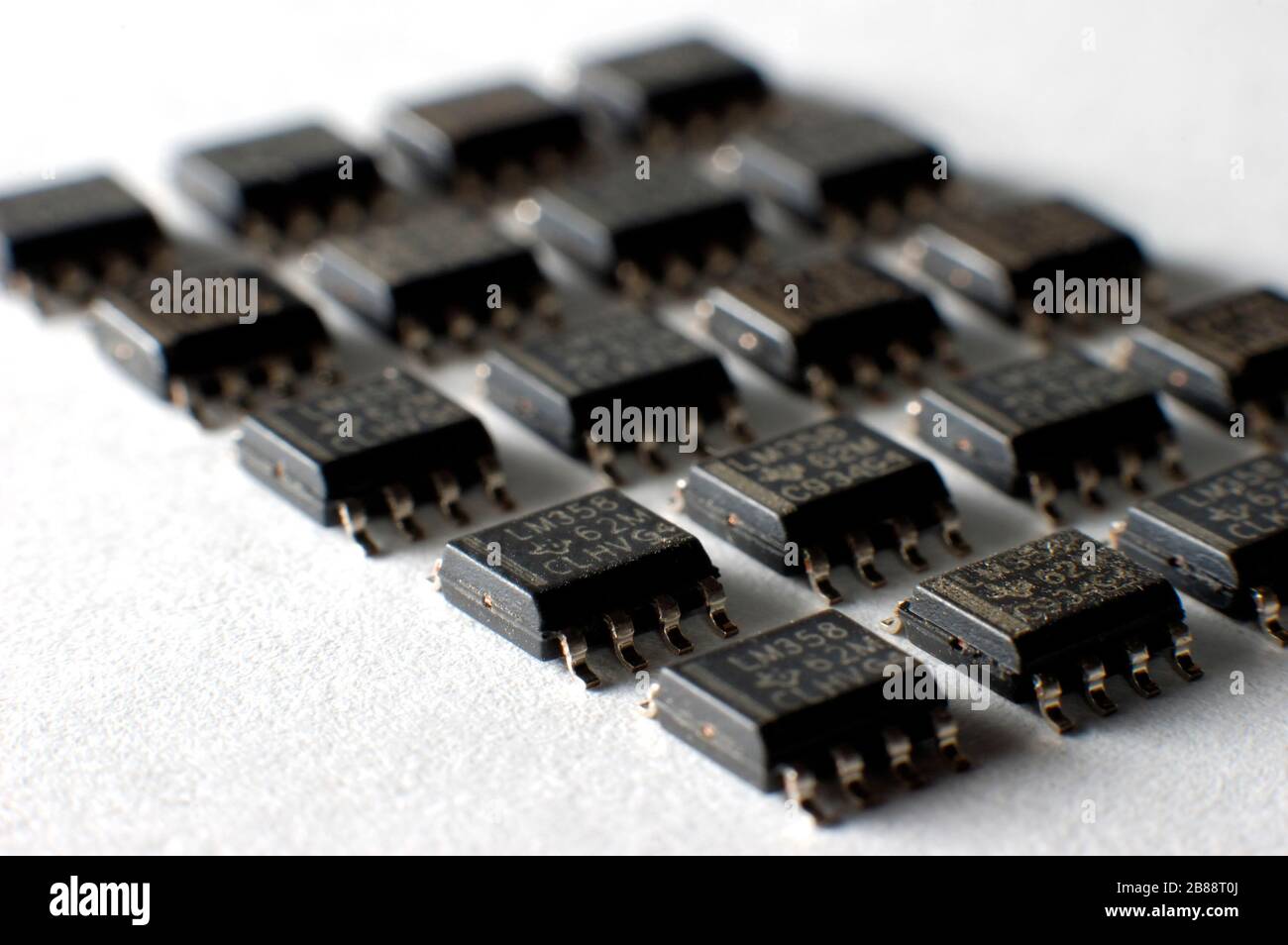 Close up SMD electronic chips in SOIC case lie of each other on a white ...