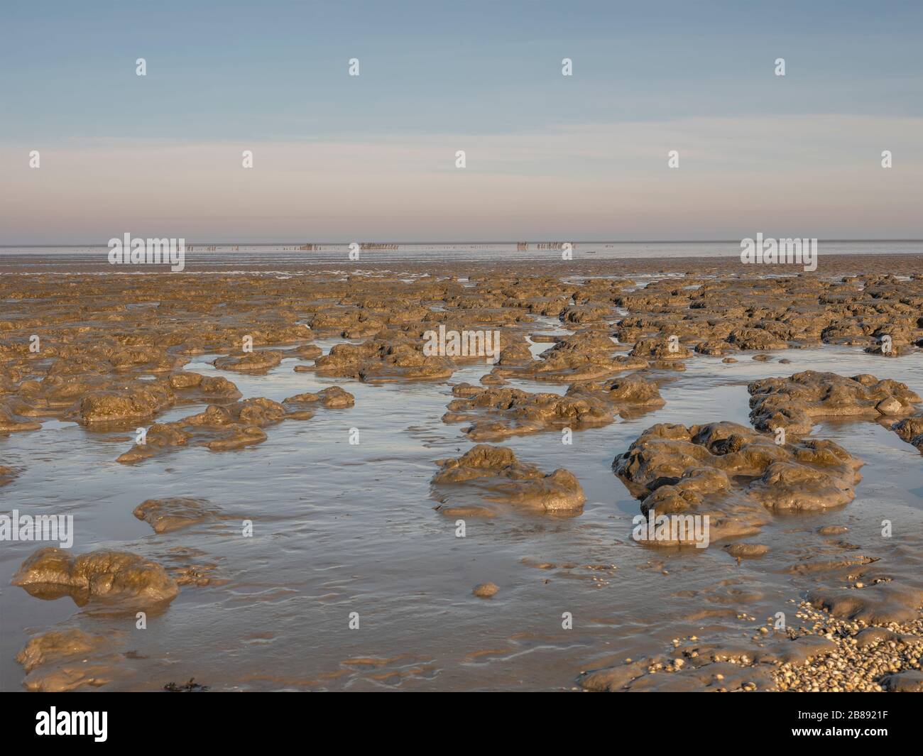 Aerial view of horizon over sea, with mounds of mud in the foreground ...