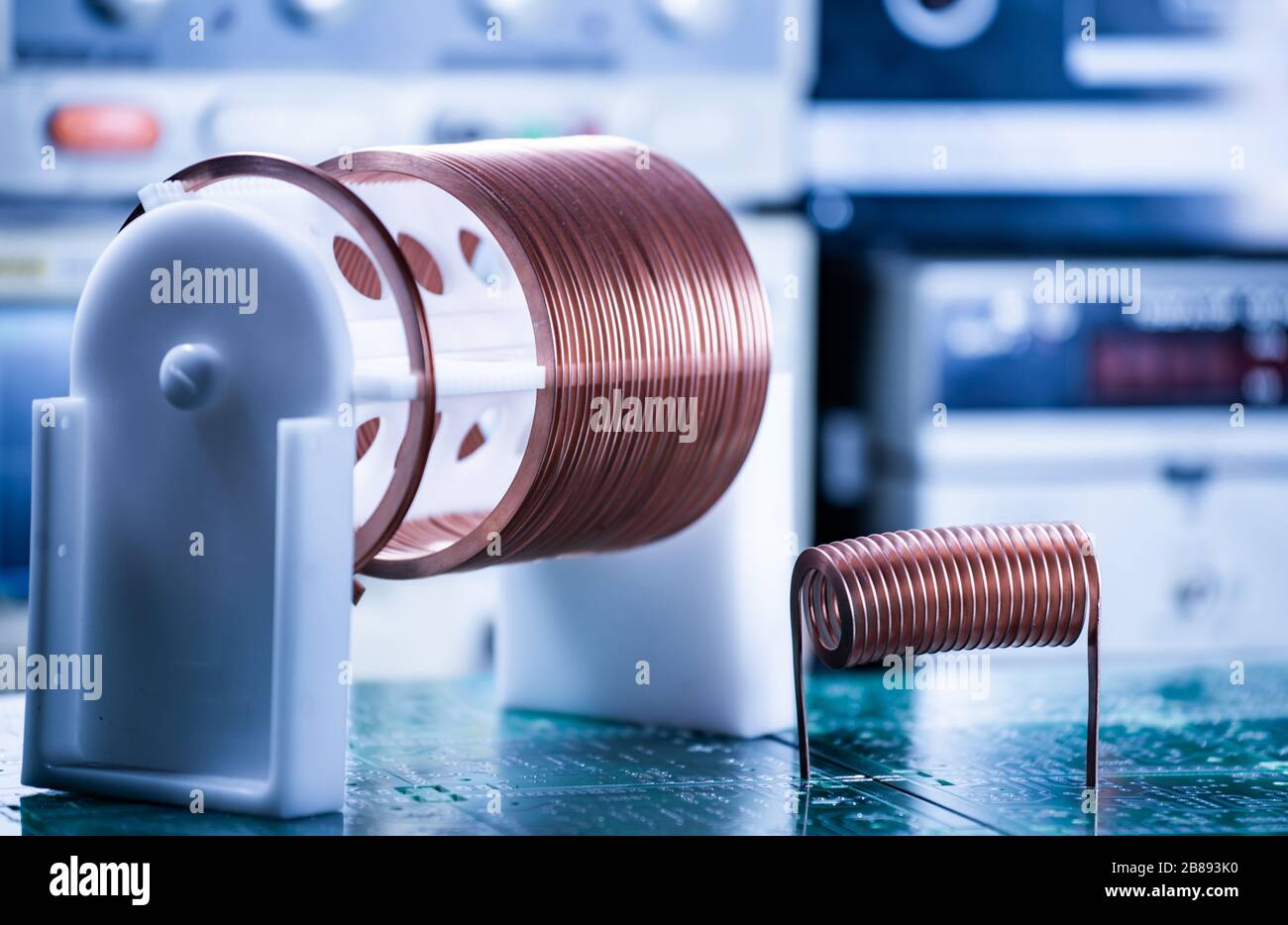 Close-up large and small coils with copper wire stand on a green ...
