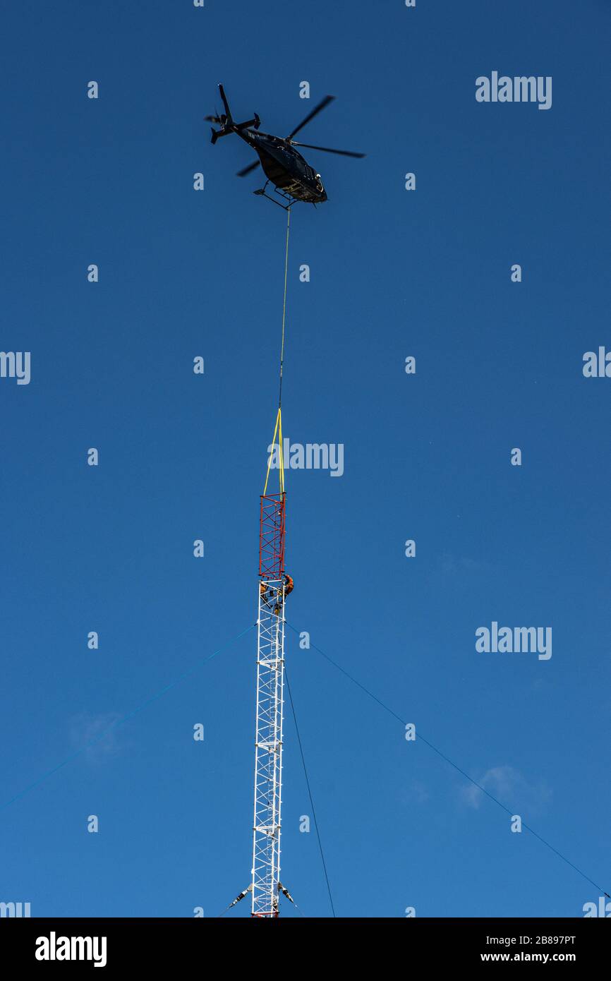 Helicopter positioning new componenet of radio mast into place Stock ...