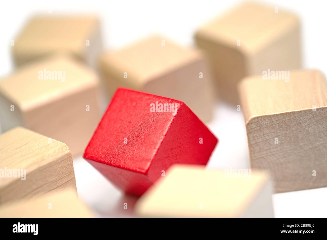 White wooden blocks and a red wooden block against a white background ...