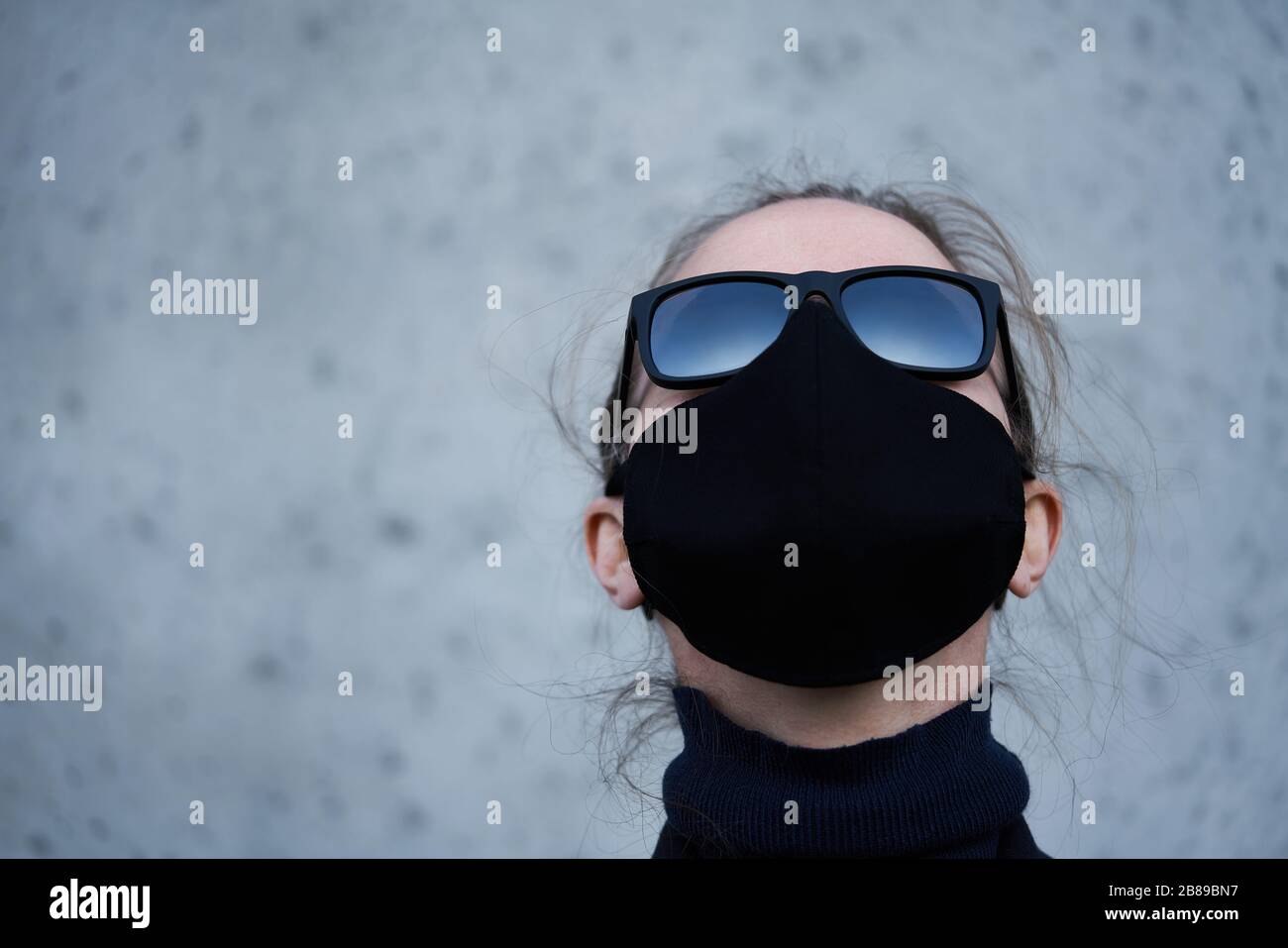 Young girl in a black protective mask and black sunglasses on the ...