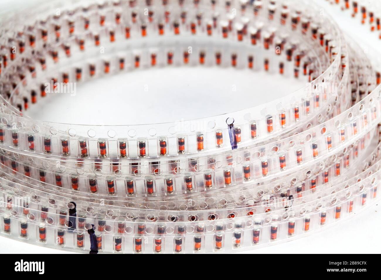 Photo of electrical part plastic tape with capacitors for electronic ...