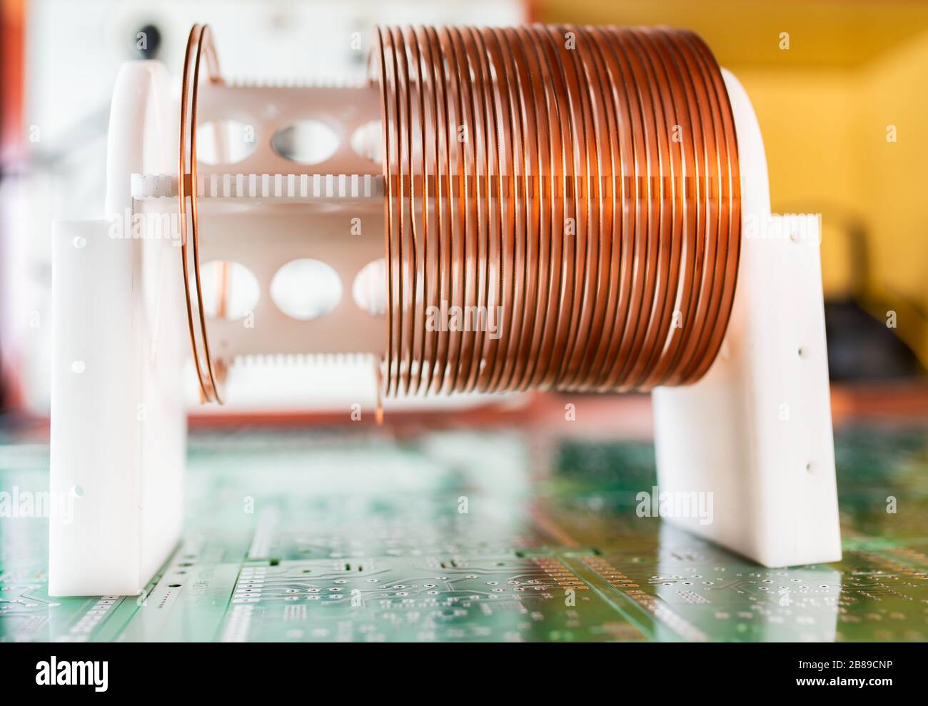 Close-up of a coil of copper wire standing on a large microcircuit ...