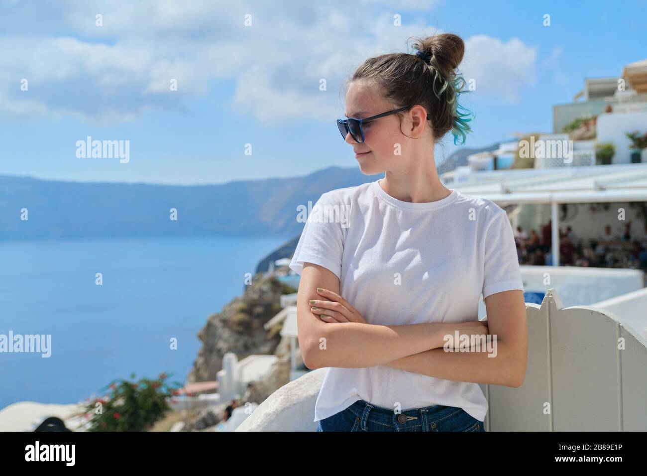 Teenager girl resting on Greek island Santorini, female looking away ...