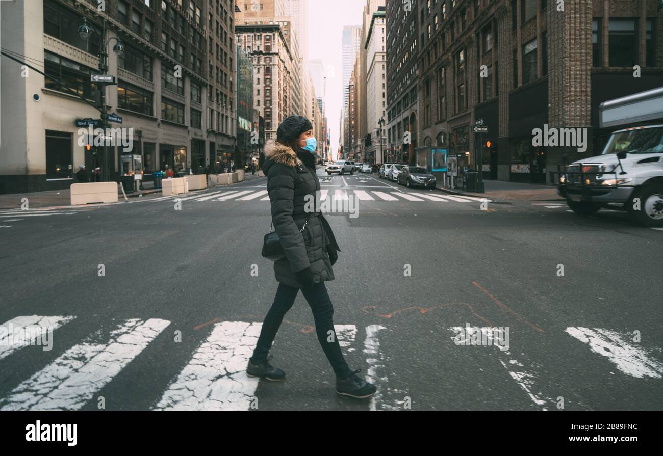 woman wearing surgical mask going through crosswalk in new york ...