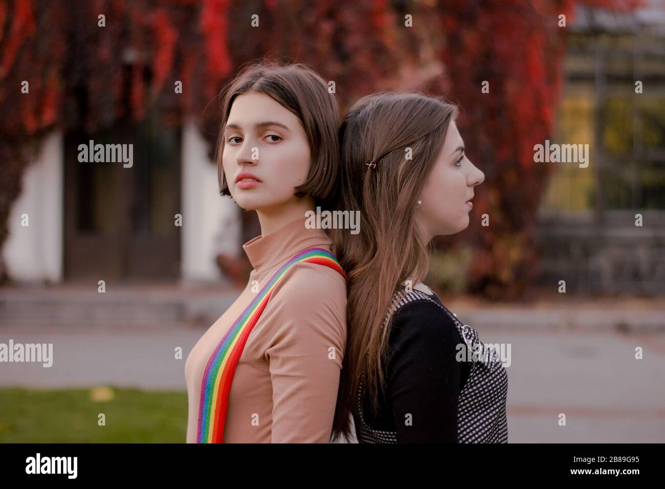 Lovely Sad girls stand back to back Stock Photo - Alamy
