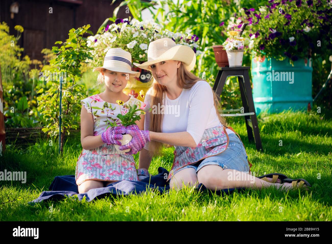 Gardening, planting - mother with daughter planting flowers into the ...