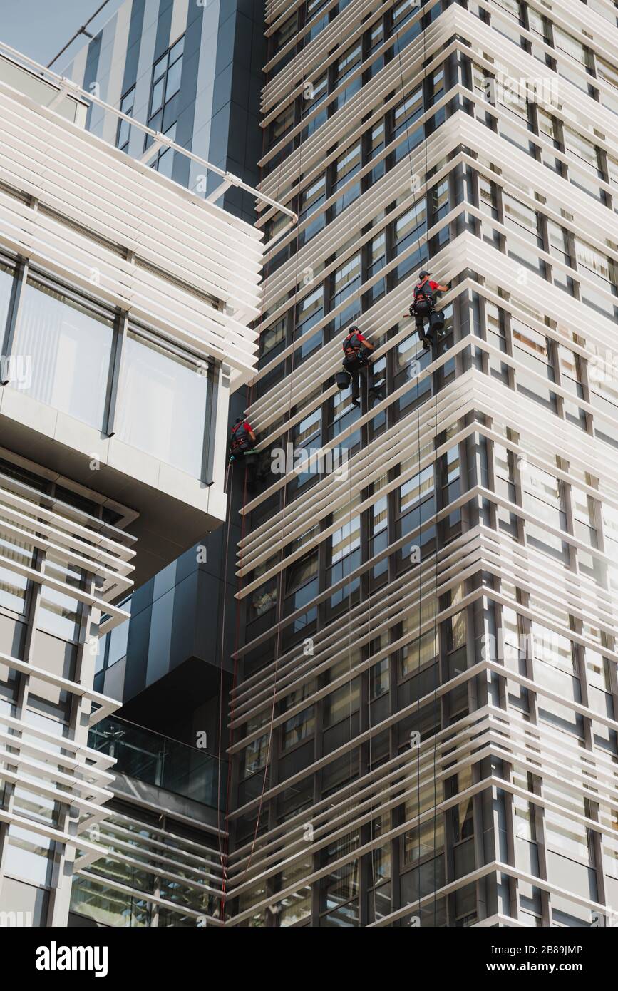 Three industrial climbers on a building Stock Photo - Alamy