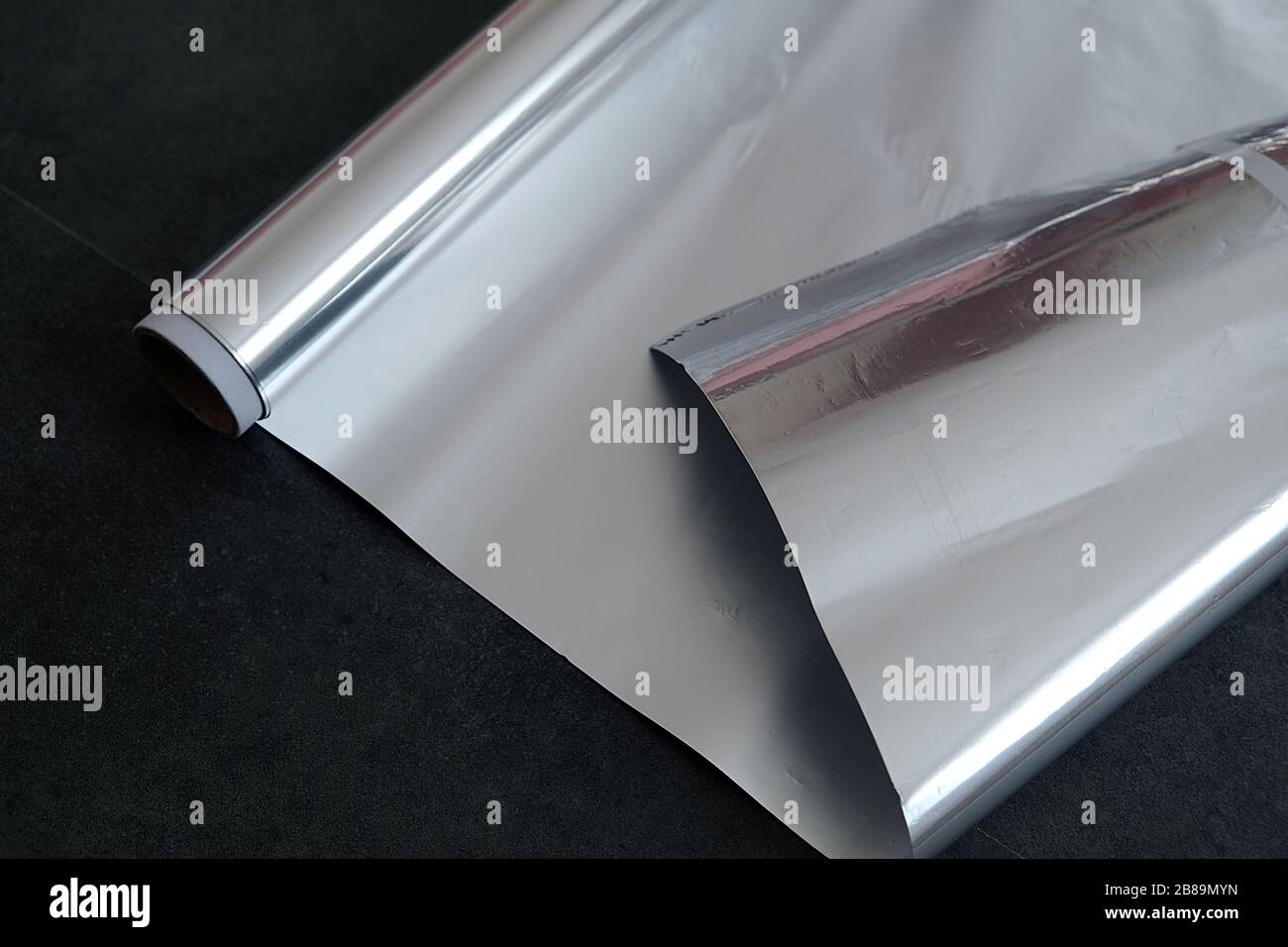 aluminum foil, rolled aluminum foil, close-up on a black background ...