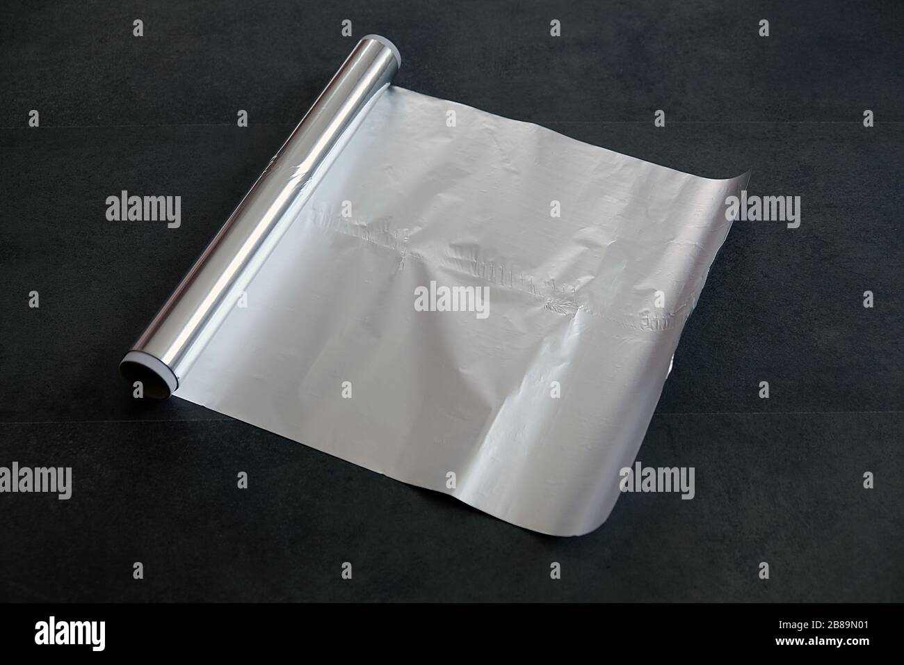 aluminum foil, rolled aluminum foil, close-up on a black background ...