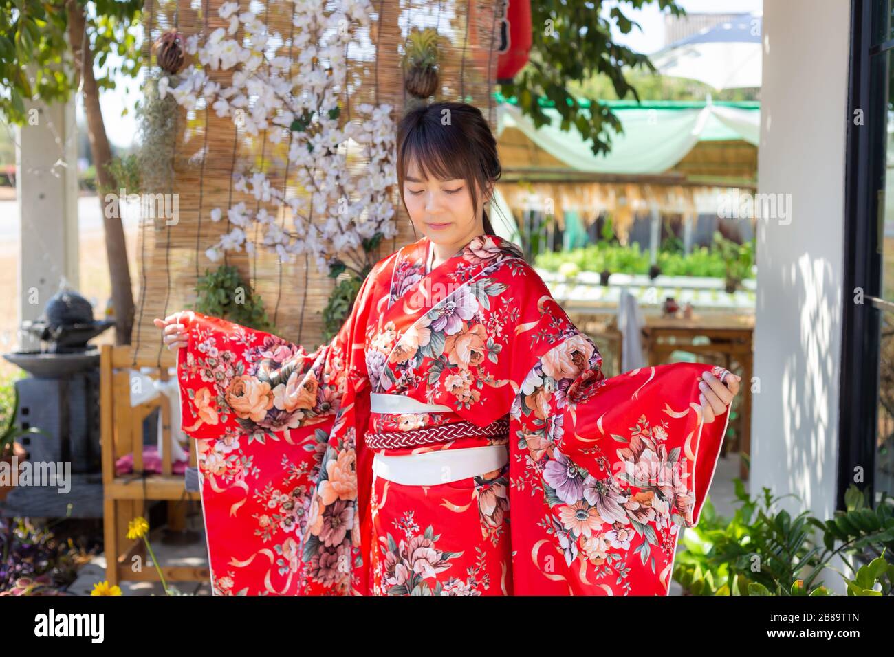 The girl is wearing a red traditional kimono, which is the national ...