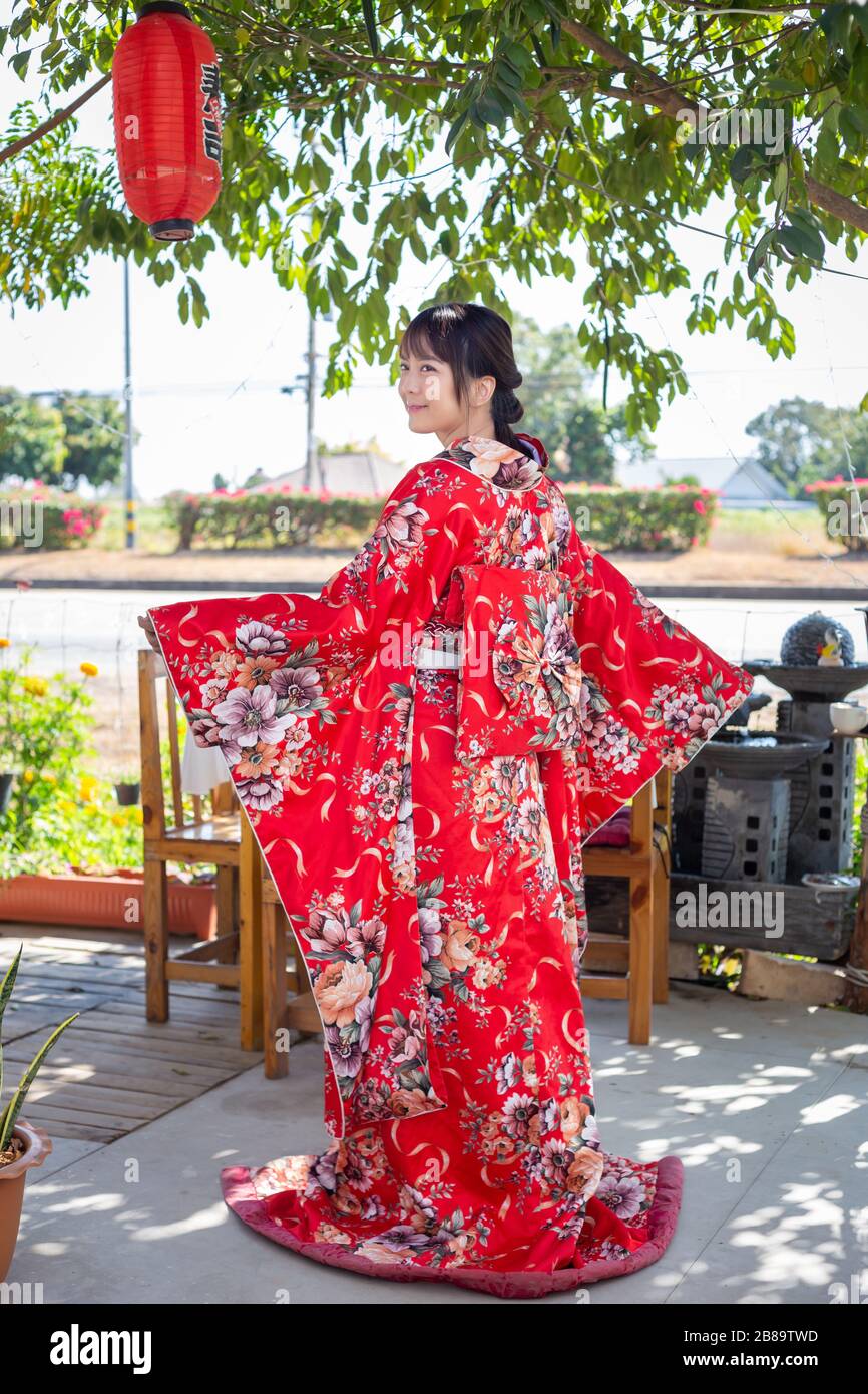 The girl is wearing a red traditional kimono, which is the national ...