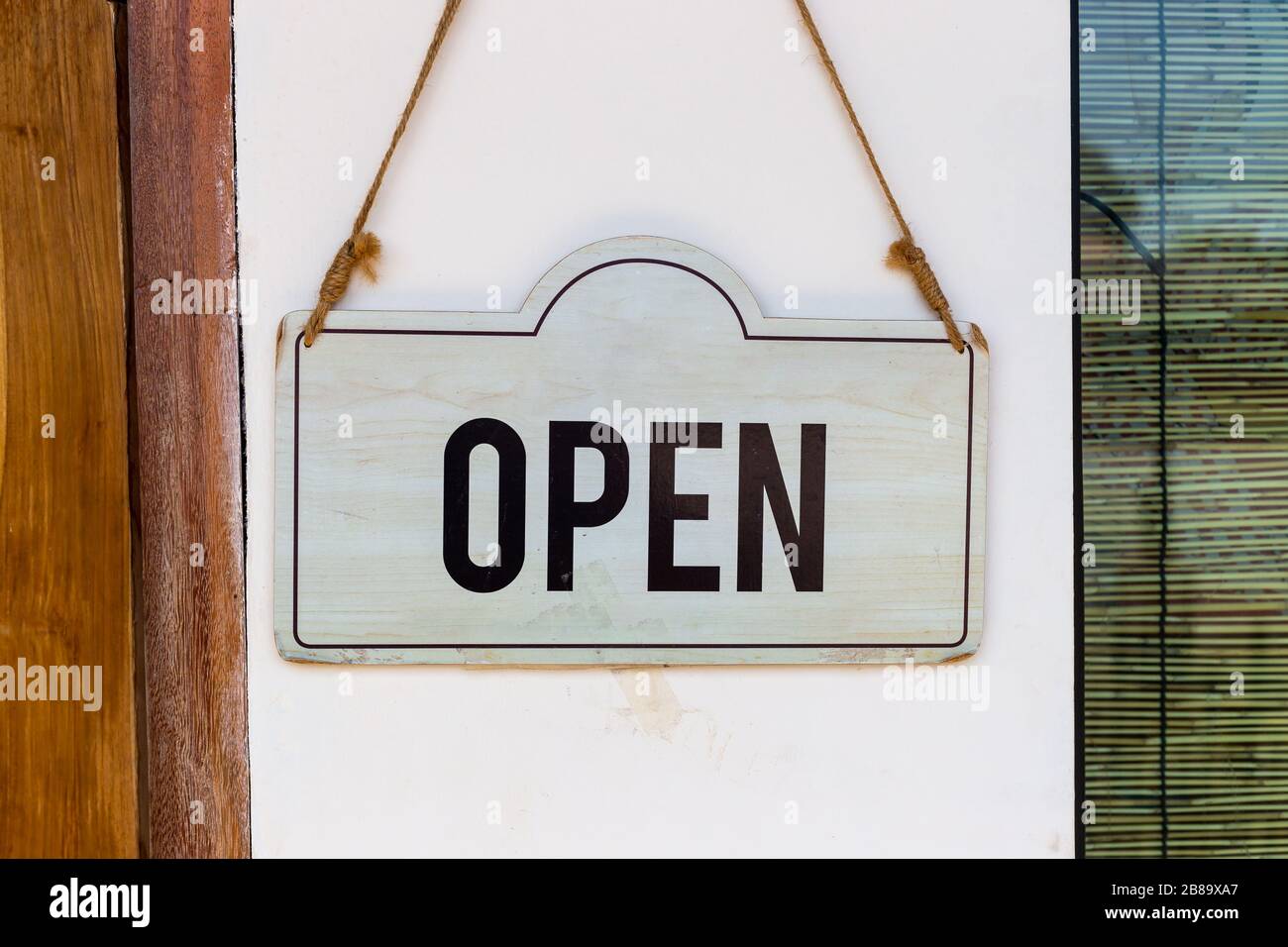 Wooden open sign board hanging on door of cafe Stock Photo - Alamy